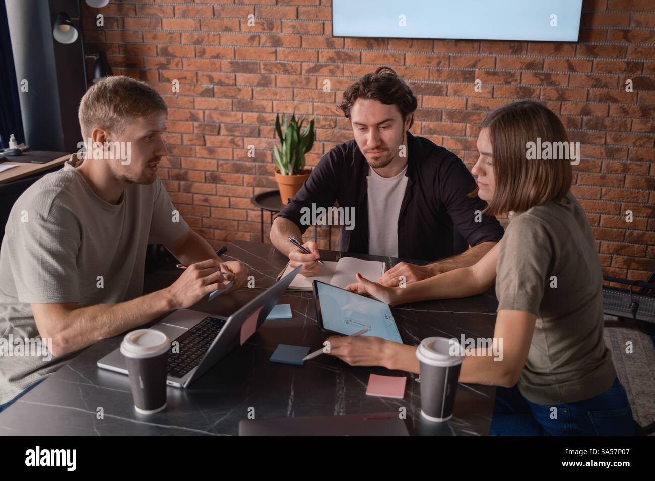 Team collaboration meeting in modern workspace with laptops and notes ...