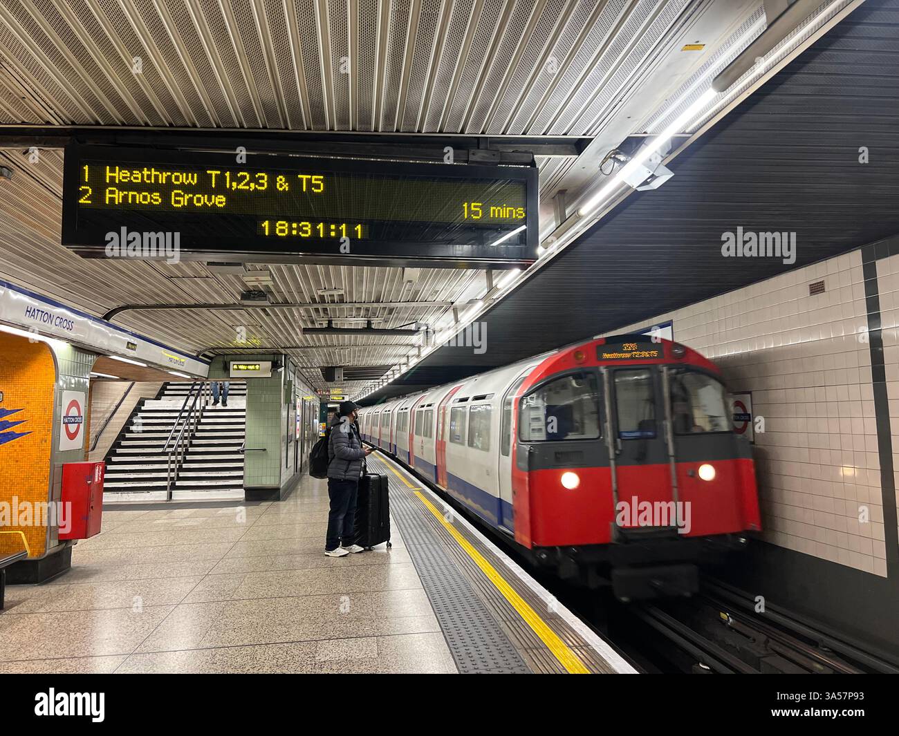 A passenger waiting to board a train at Hatton Cross station in London ...