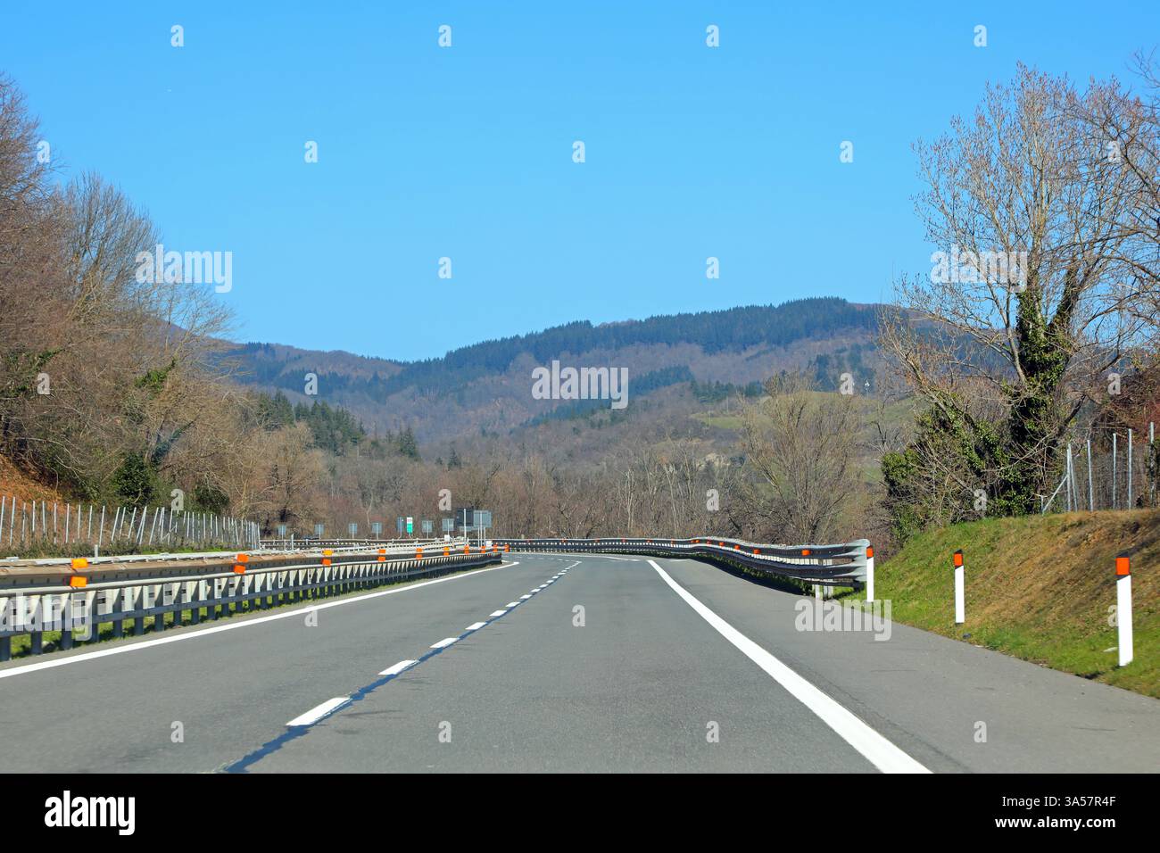 curve of a two-lane road without cars in the middle of the hills ...