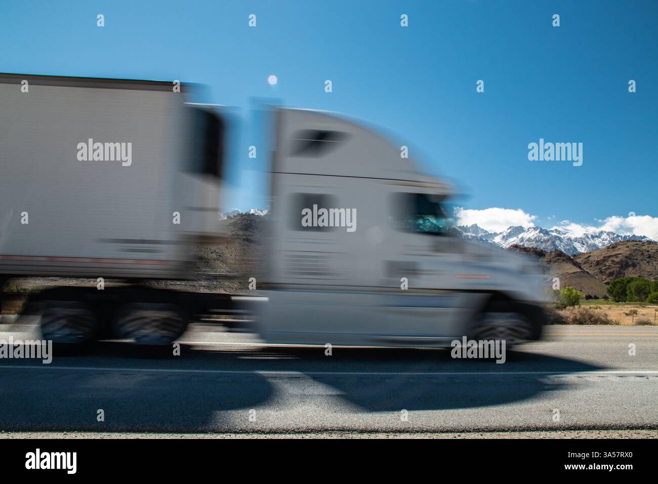 A fast moving tractor trailer rig transports cargo over the highway ...