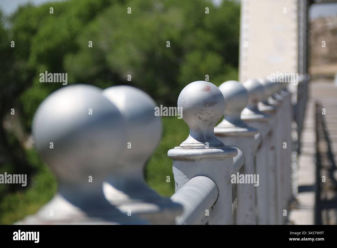 A row of ball finials along the top of a steel railing of a bridge ...