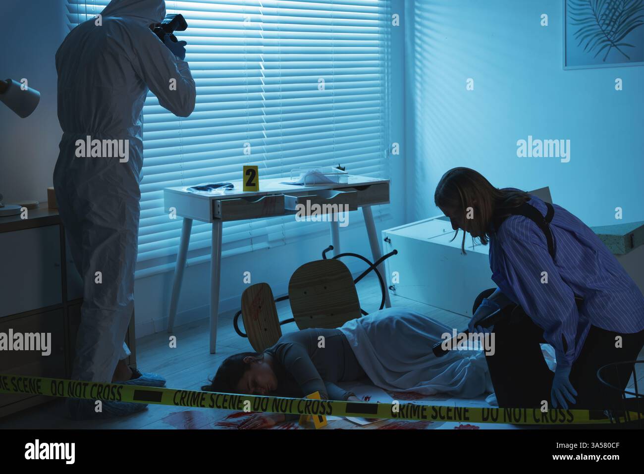 Forensic experts working at crime scene with dead woman's body indoors ...
