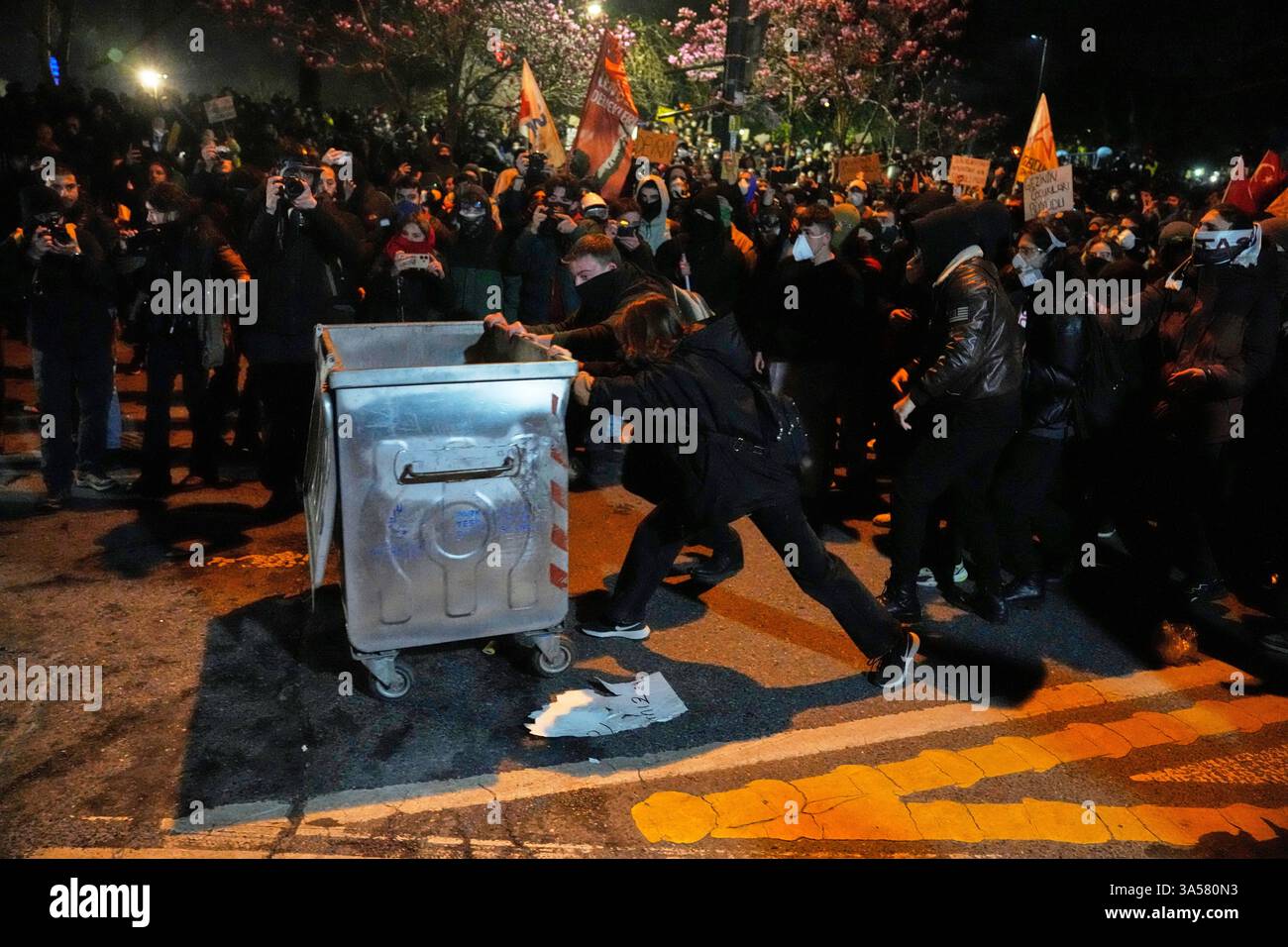 Protesters push a metal trash bin against anti riot police men during ...