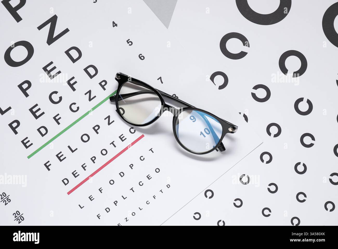 Glasses and vision test charts on table, top view Stock Photo - Alamy