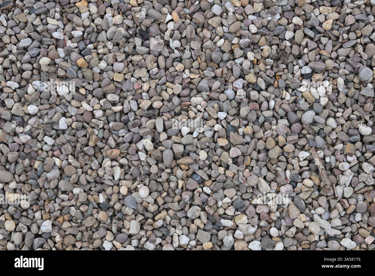 A pile of rocks with a few white ones mixed in. The rocks are of ...