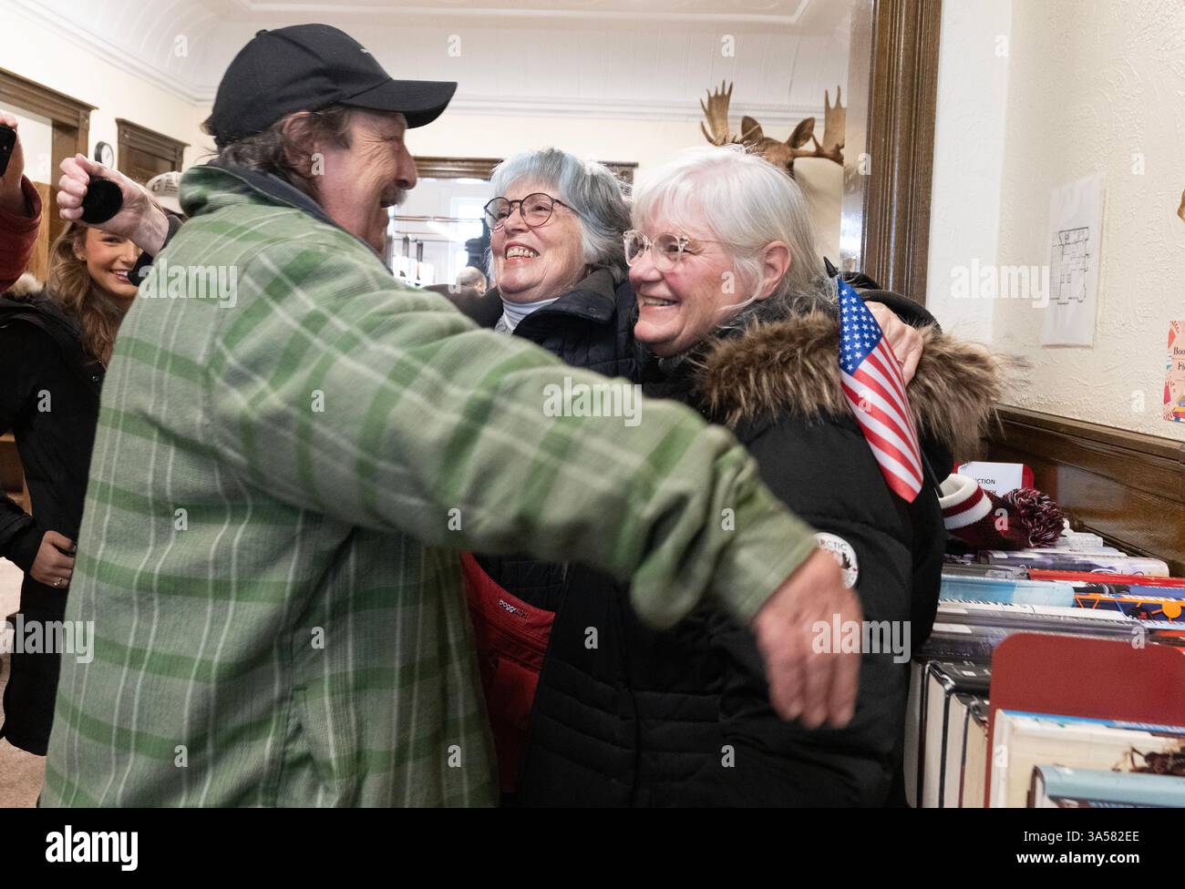 Byron Wright, left, from Derby, Vermont, gives Pauline Lussier, centre from Stanstead, Quebec ...