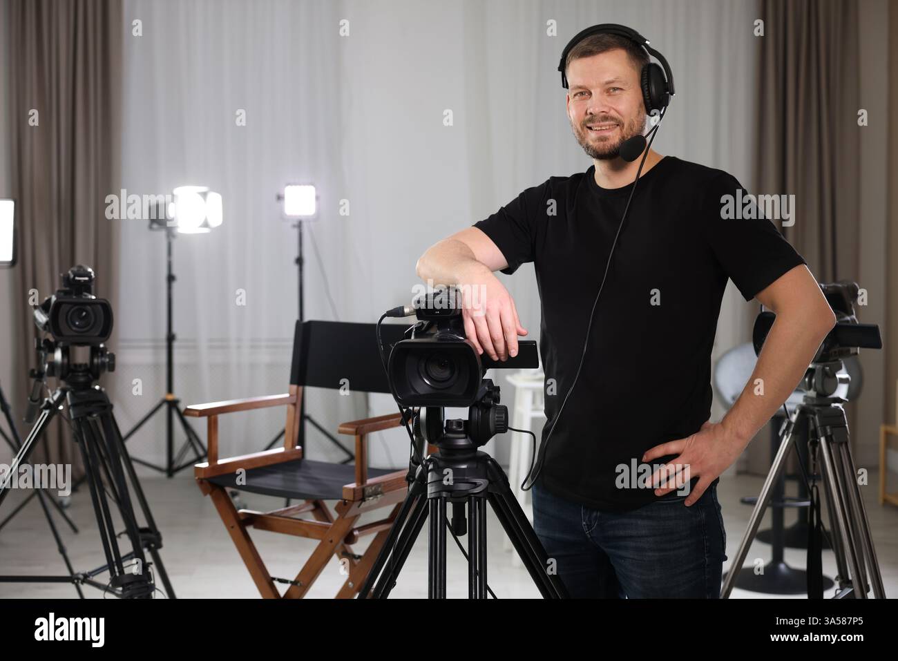 Cameraman with camera and headphones in film studio Stock Photo - Alamy
