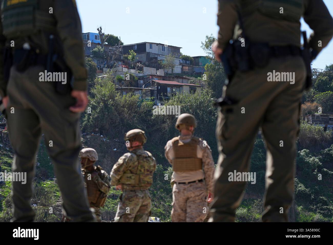 Border Patrol agents and members of the military look towards Tijuana ...