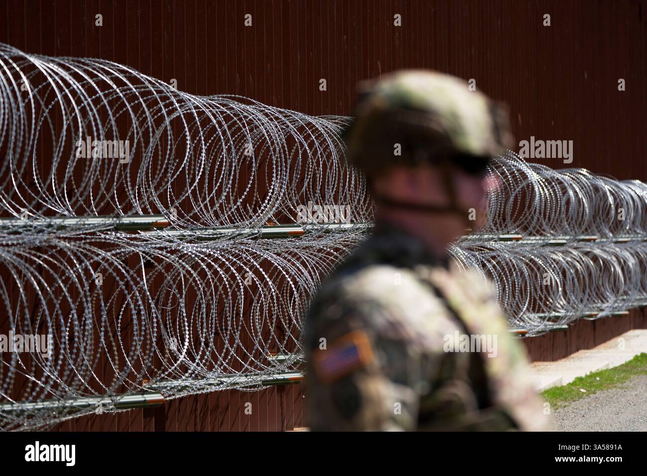 A member of the military looks on in front of newly installed ...