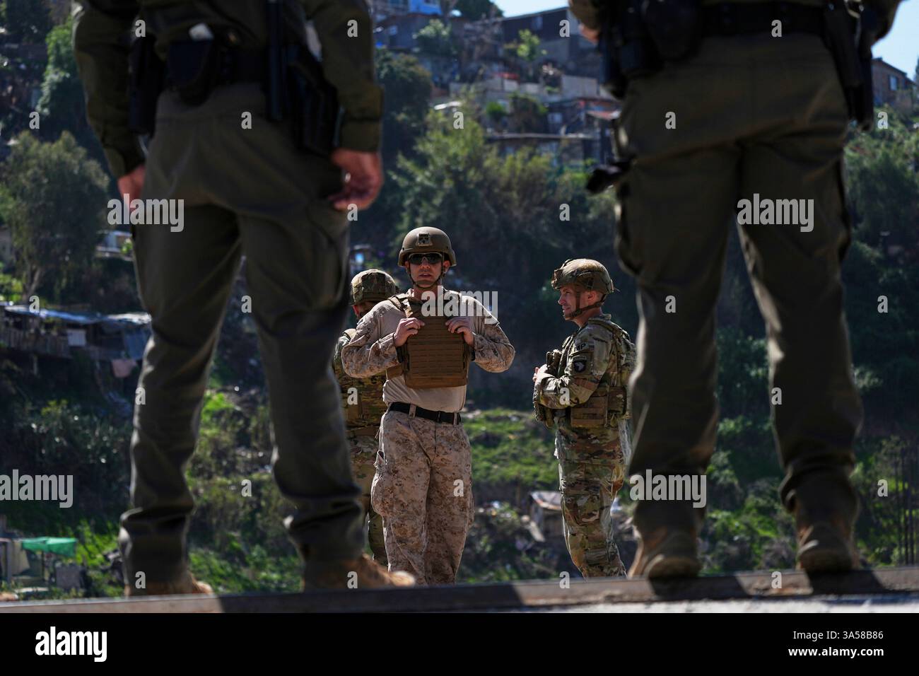 Border Patrol agents and members of the military look towards Tijuana ...