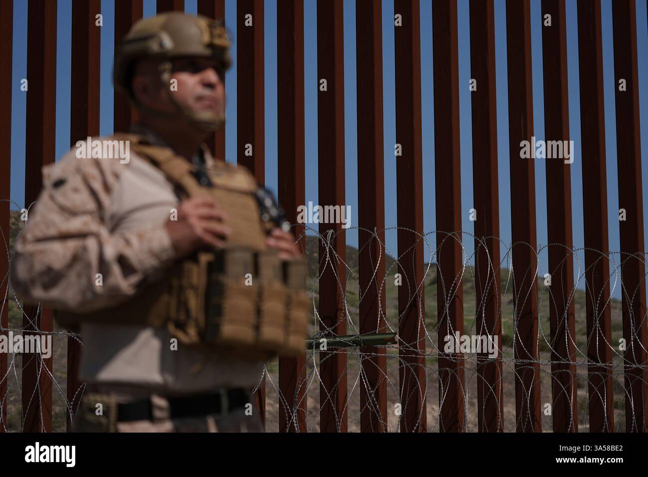A Marine looks on in front of newly-installed concertina wire lining ...