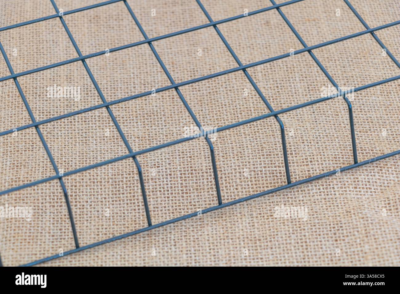 A close-up shot of the metal mesh grid on burlap fabric, highlighting ...