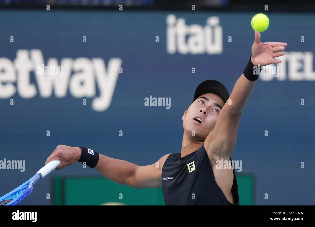 Rinky Hijikata, of Australia, serves to Novak Djokovic, of Serbia ...