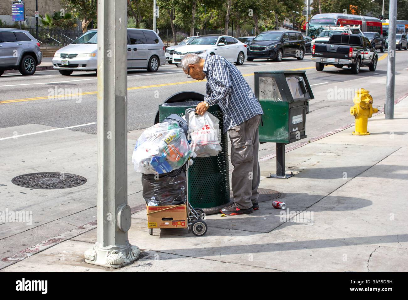 Homeless man shopping cart digging hi-res stock photography and images ...