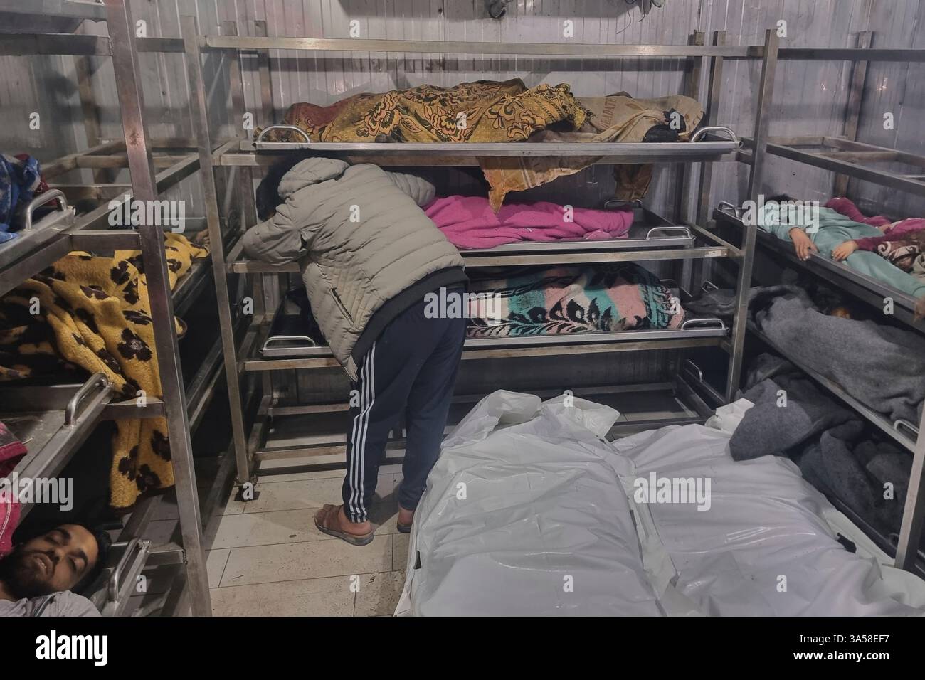 FILE - A man mourns over the body of a child in a hospital morgue ...