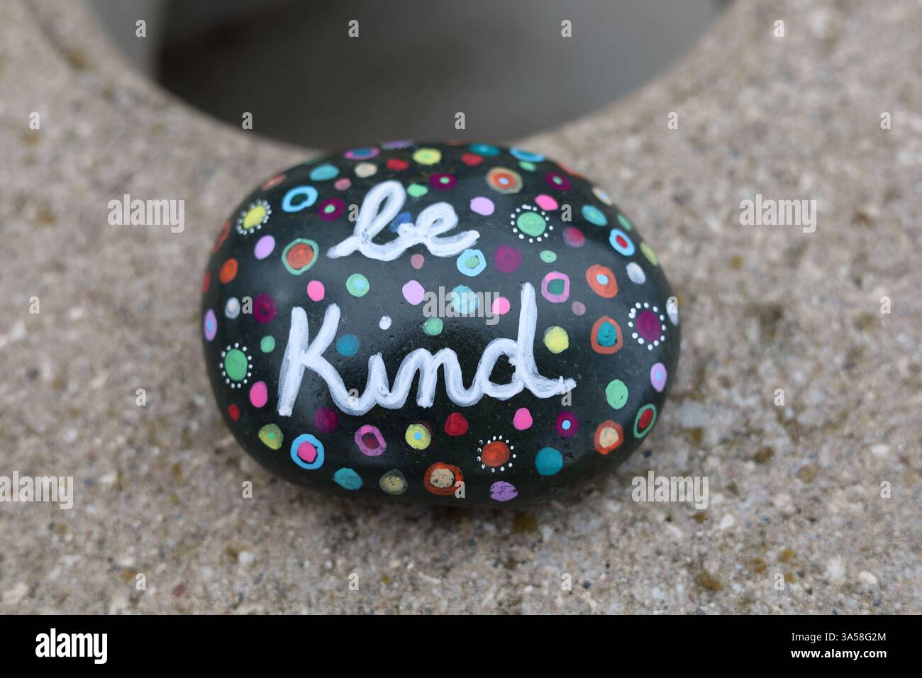 Be kind kindness rock by concrete opening on cornhole outdoor game ...