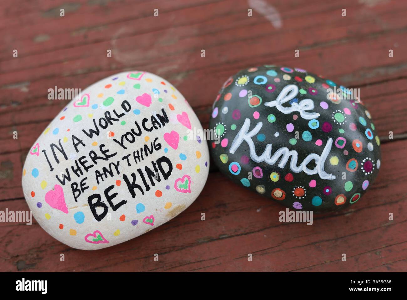 Two be kind kindness rocks on weather wooden picnic table surface Stock ...