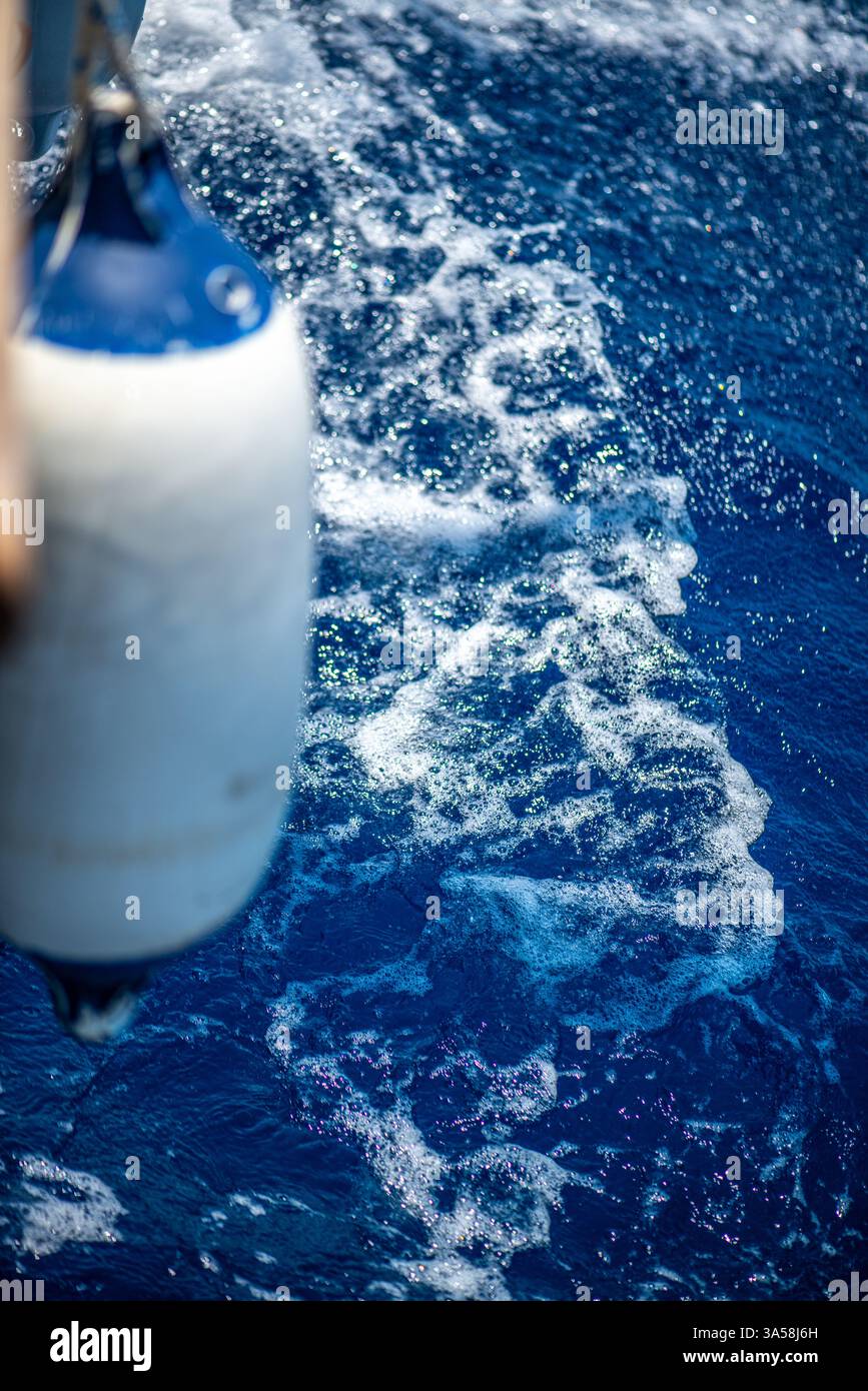 A detailed close-up of a fender secured to a sailboat, gently touching ...