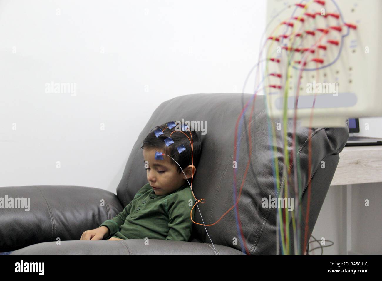 EEG electroencephalogram of a 3-year-old Latino boy with cables and ...