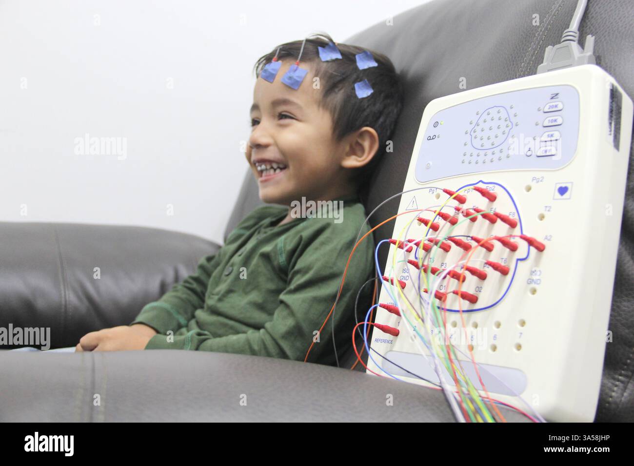 EEG electroencephalogram of a 3-year-old Latino boy with cables and ...