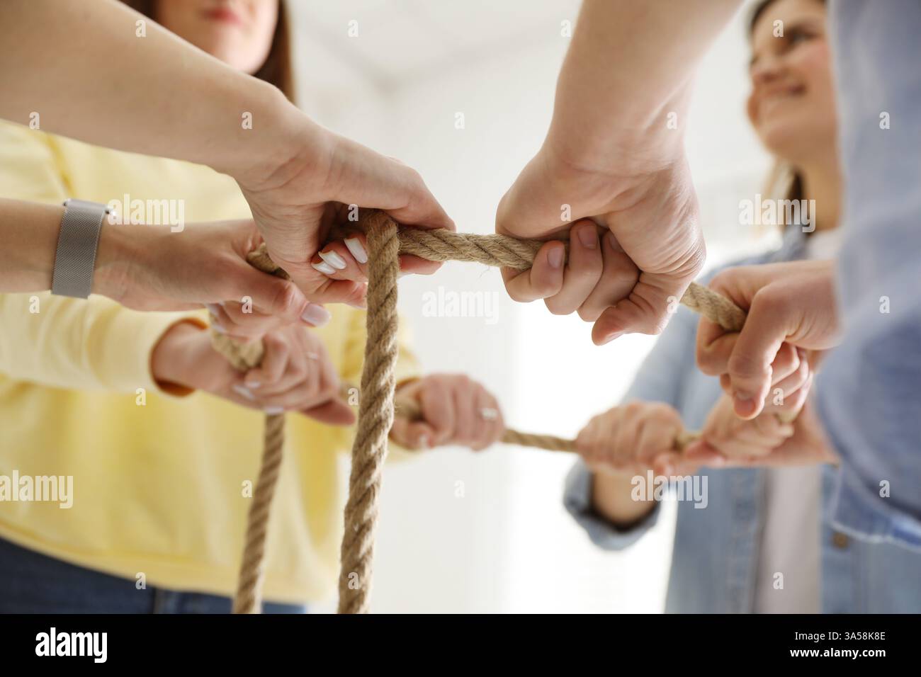 Unity concept. People holding rope together indoors, closeup Stock ...