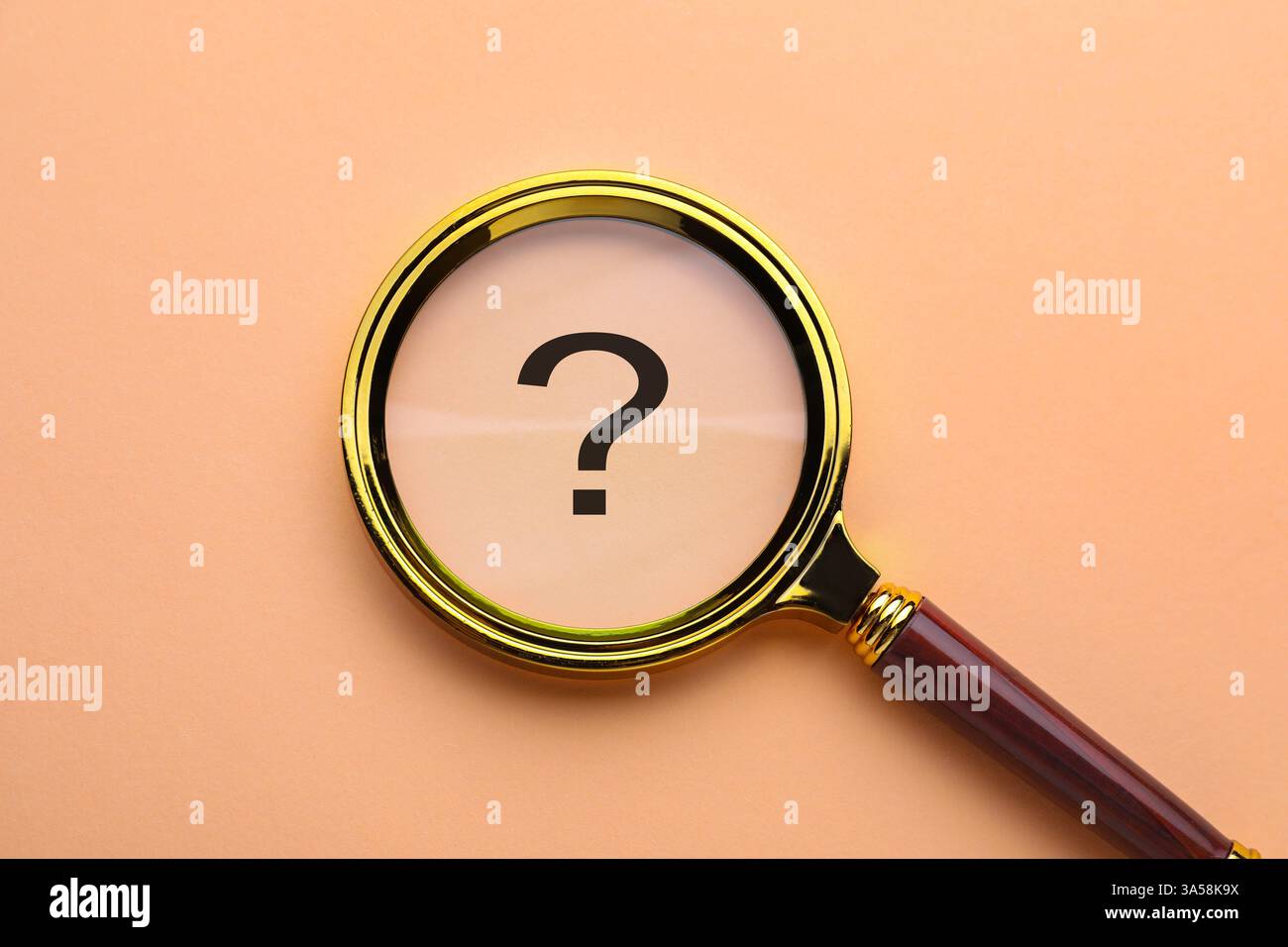 Question mark on peach color background, top view through magnifying ...