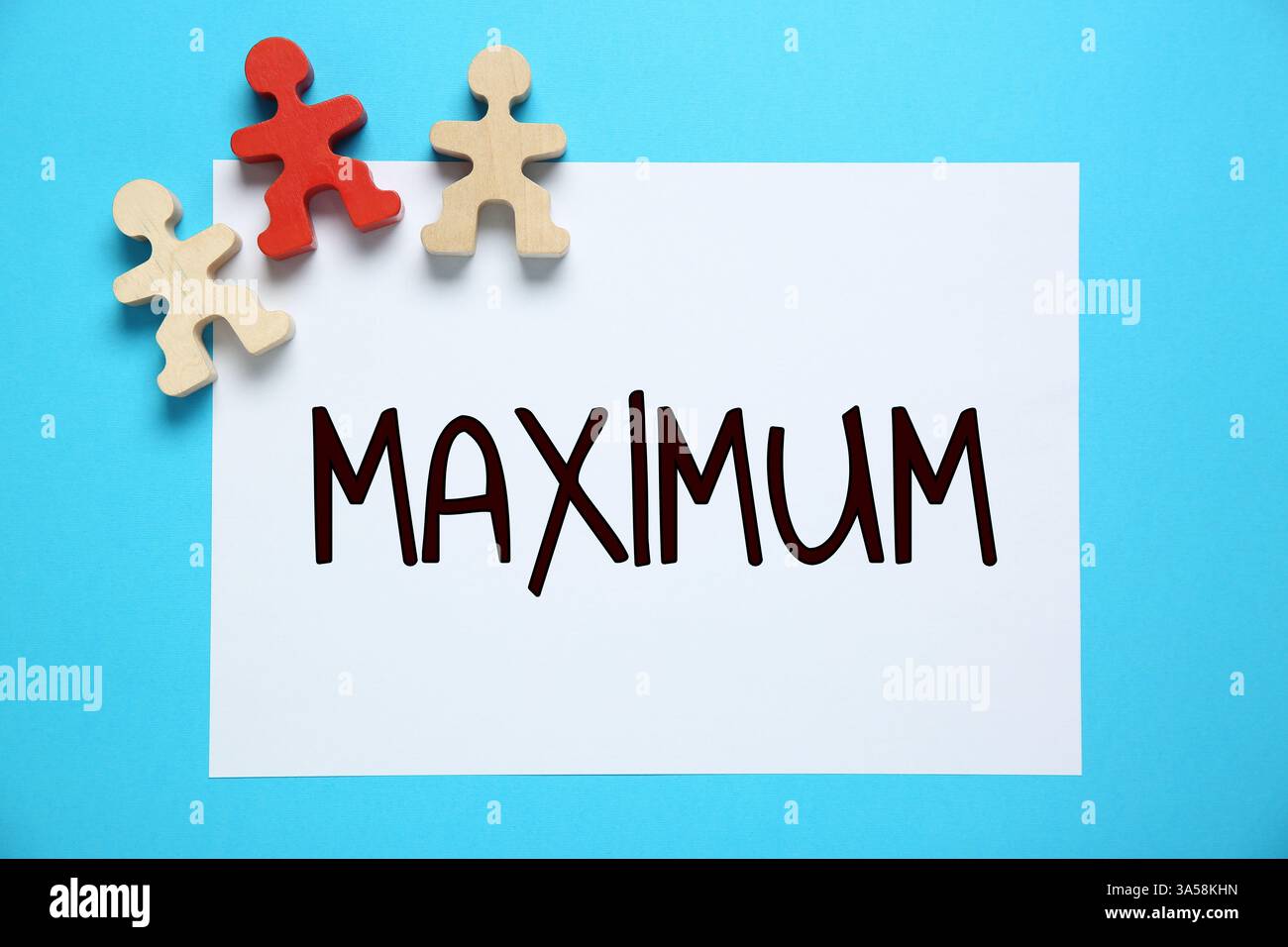 Paper sheet with word Maximum and human figures on light blue ...