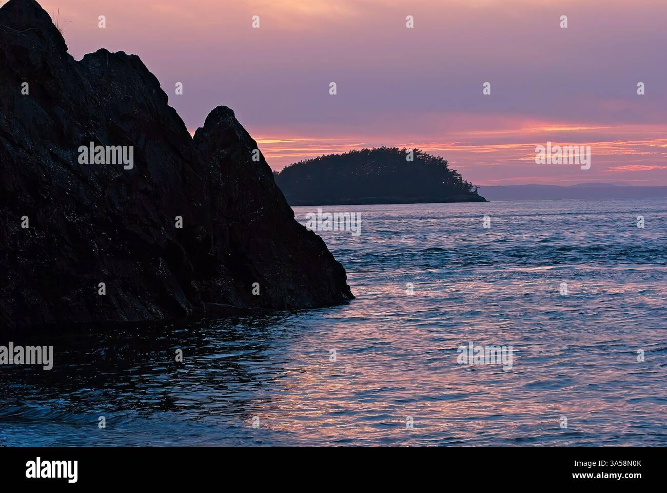 Illuminated sky, and reflection on water surface at sunset over ...