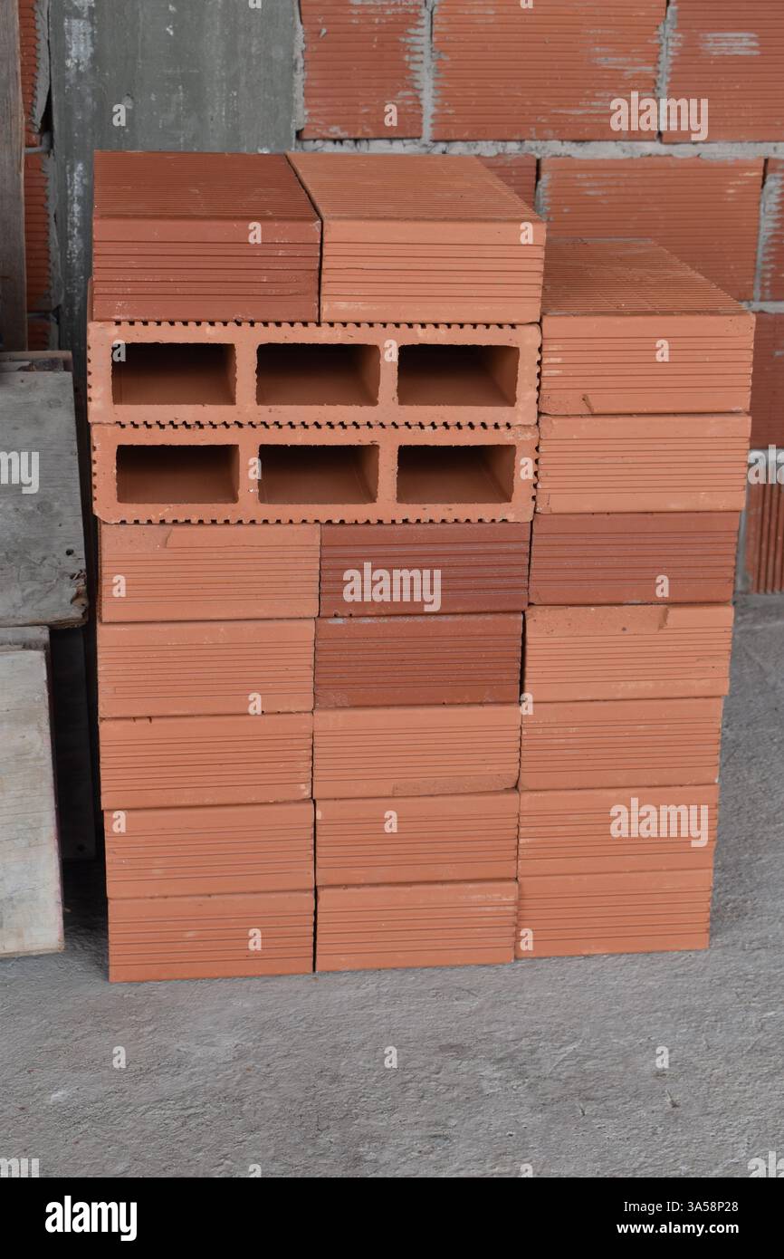 A stack of red concrete bricks or blocks at a construction site in ...