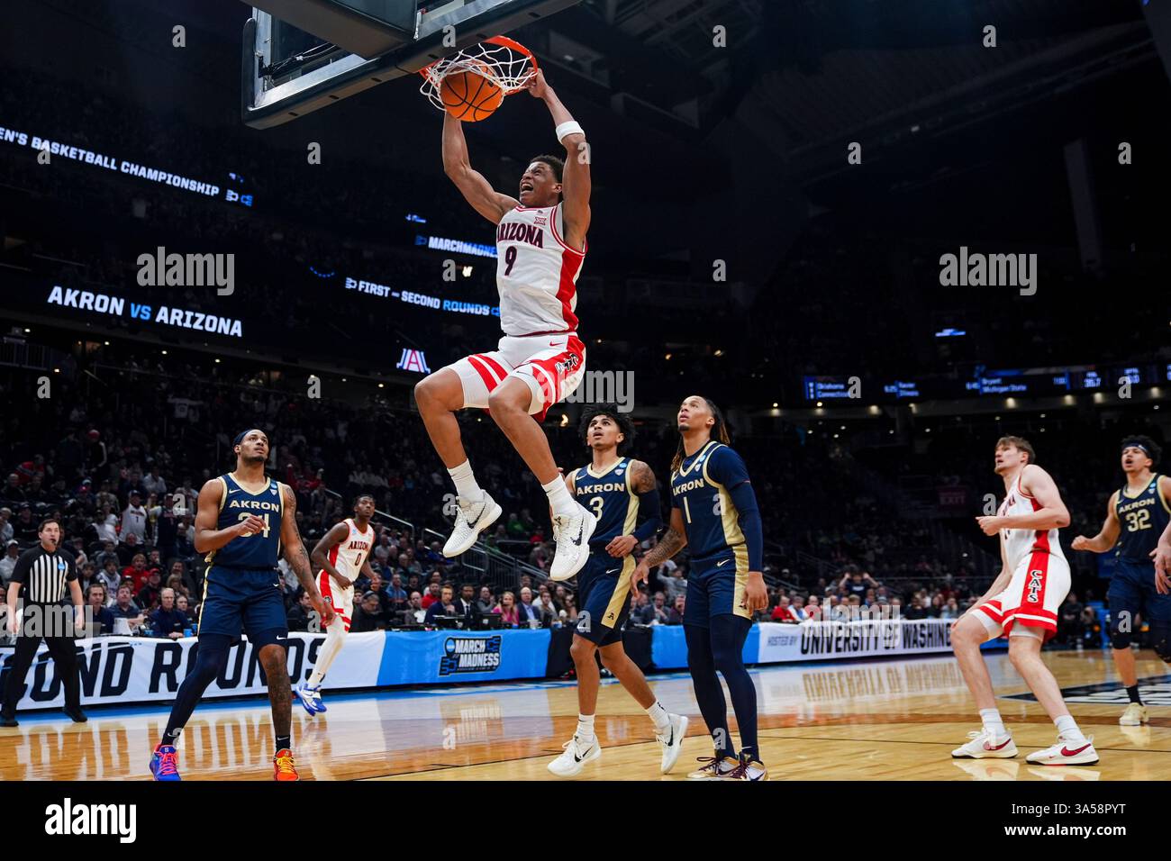 Arizona forward Carter Bryant (9) dunks as Akron guard Nate Johnson ...
