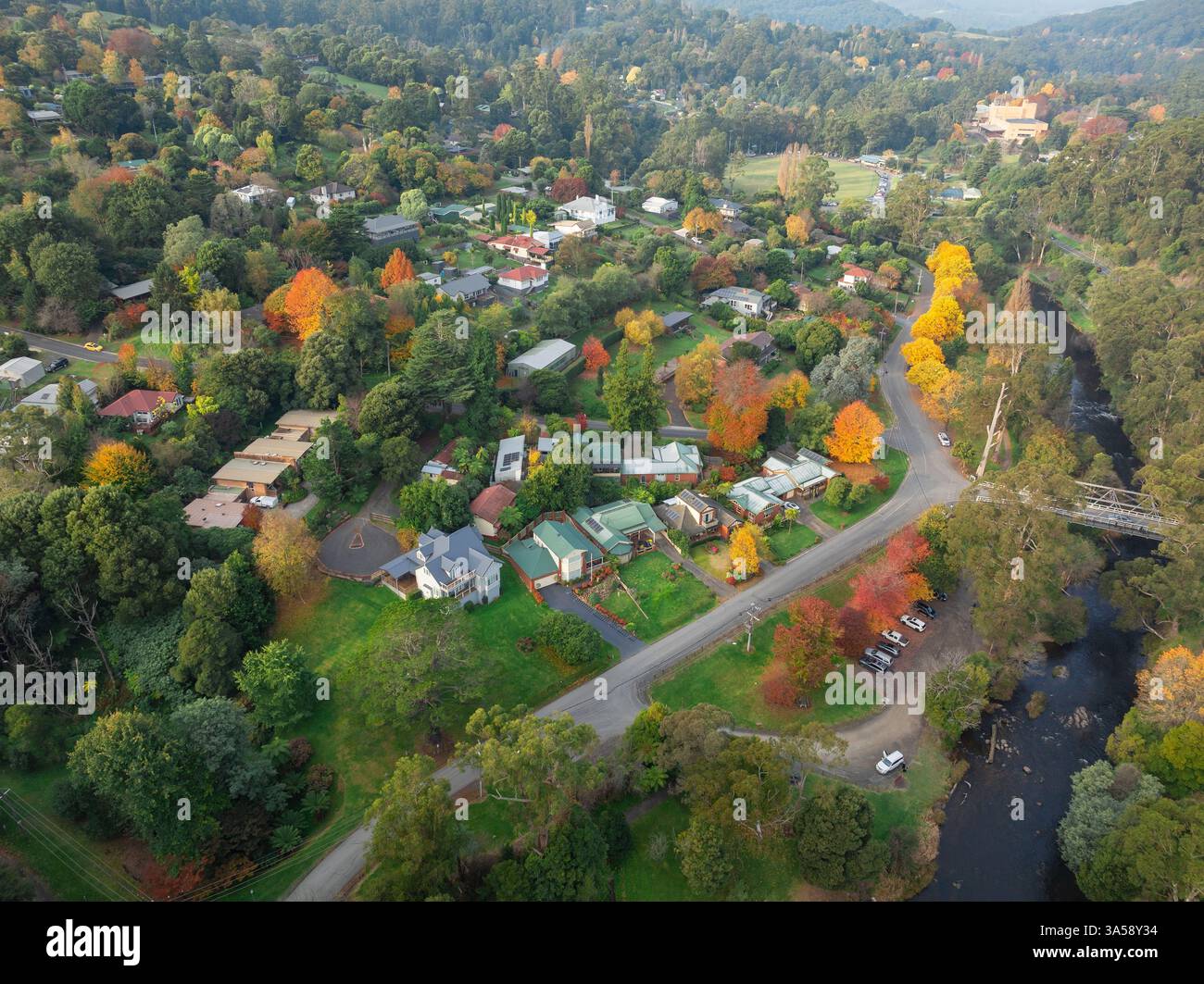 Aerial view of a small country town nested ina valley during Autumn at ...