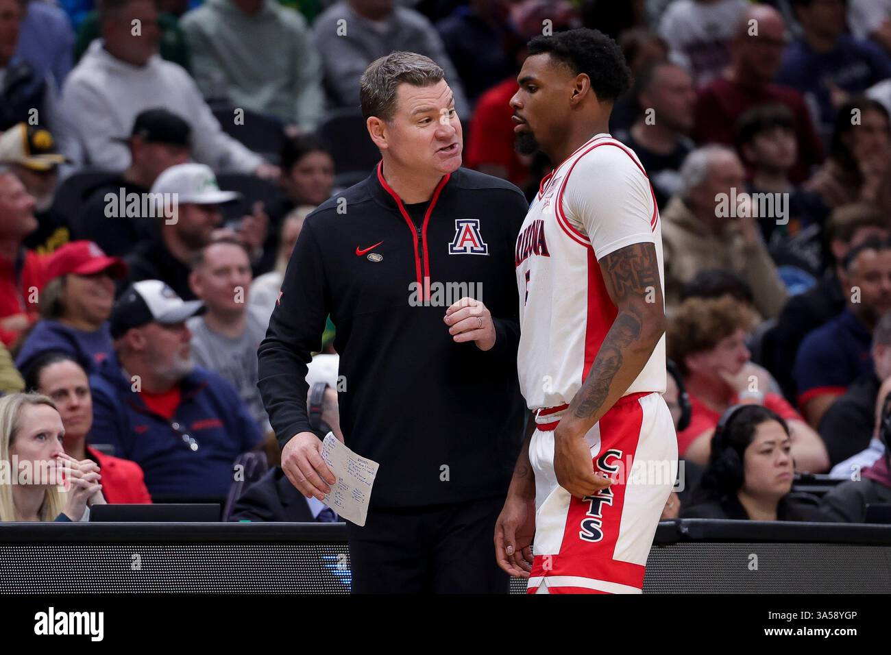 Arizona head coach Tommy Lloyd, left, talks with guard KJ Lewis during ...