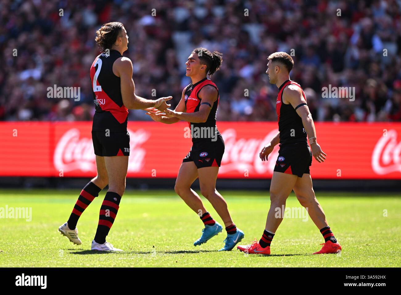 Isaac Kako of Essendon (centre) celebrates a goal kicked by Sam Draper ...
