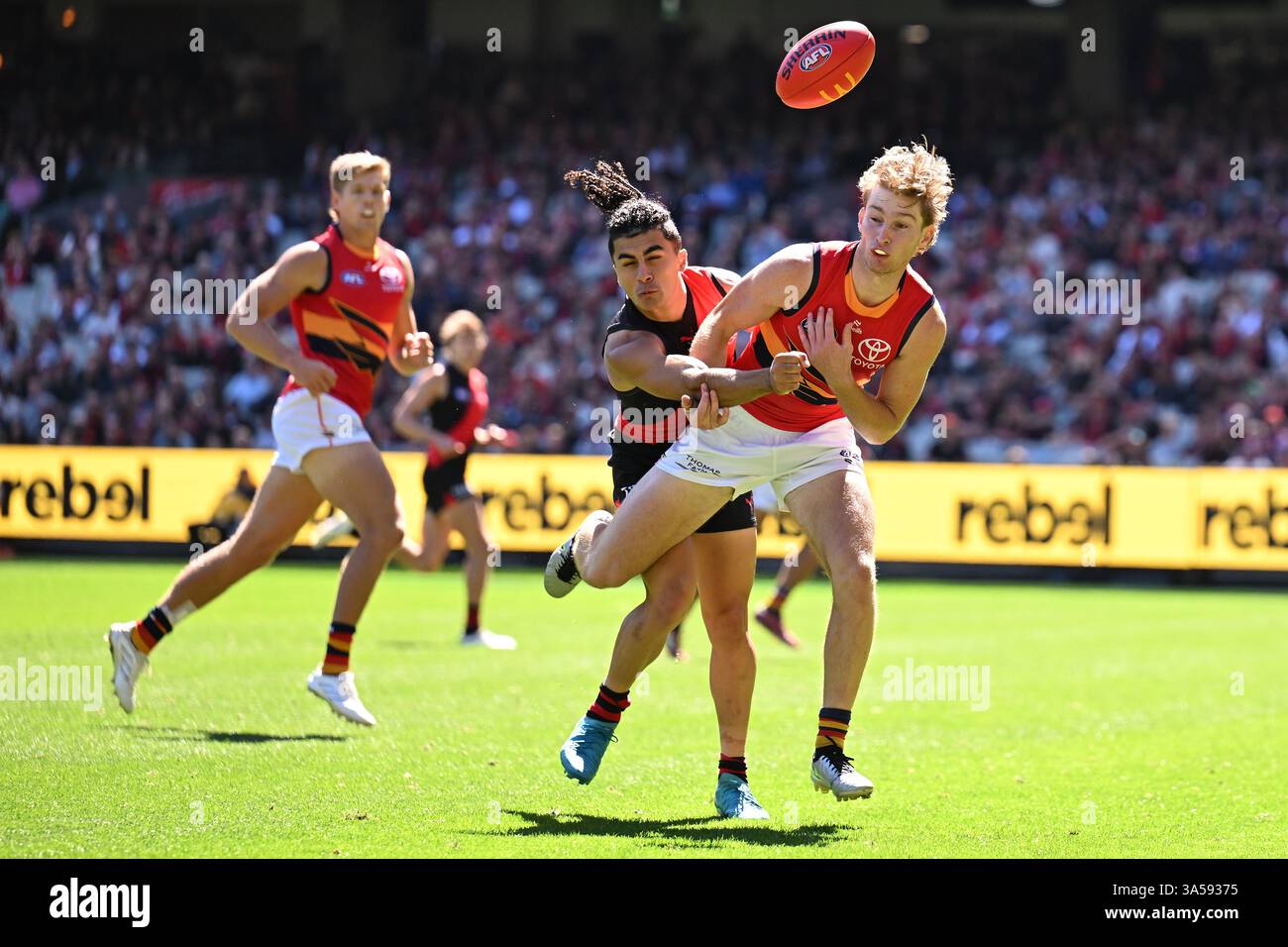 Isaac Kako of Essendon (centre) and Max Michalanney of the Crows ...
