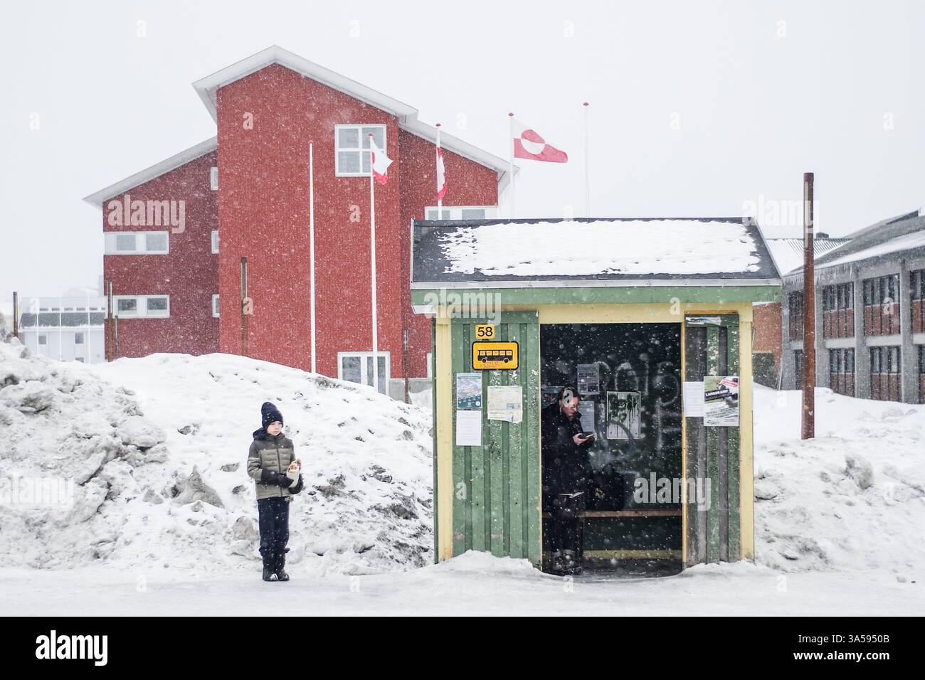 Beijing, Denmark. 19th Mar, 2025. A boy waits for bus in the snow with ...