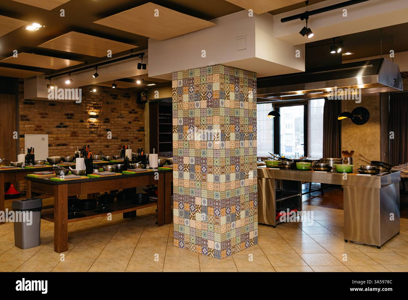 A spacious professional kitchen with rustic brick walls, tiled columns ...