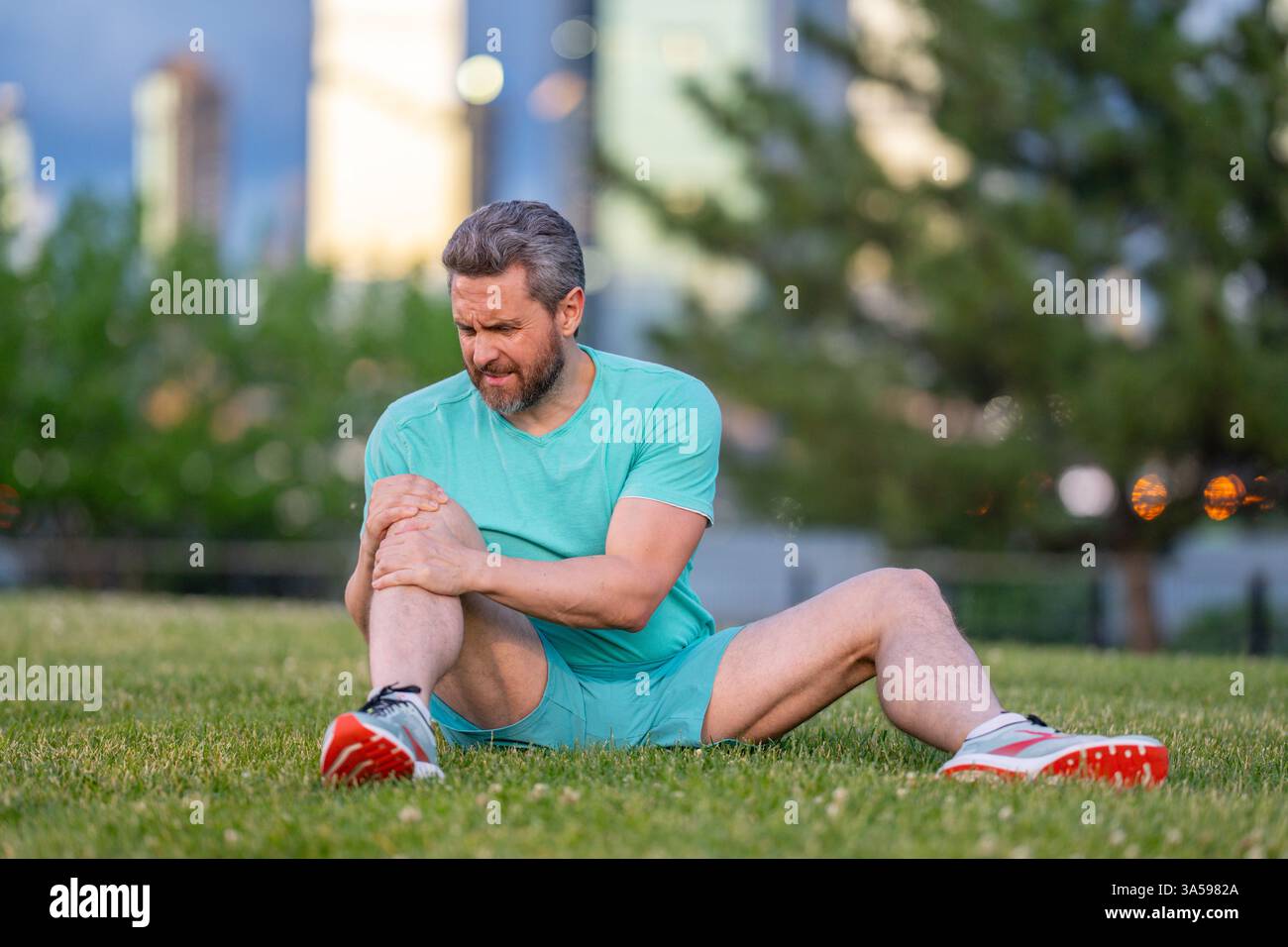 Broken knee after workout. Leg hurt during jogging. Injured man holding ...