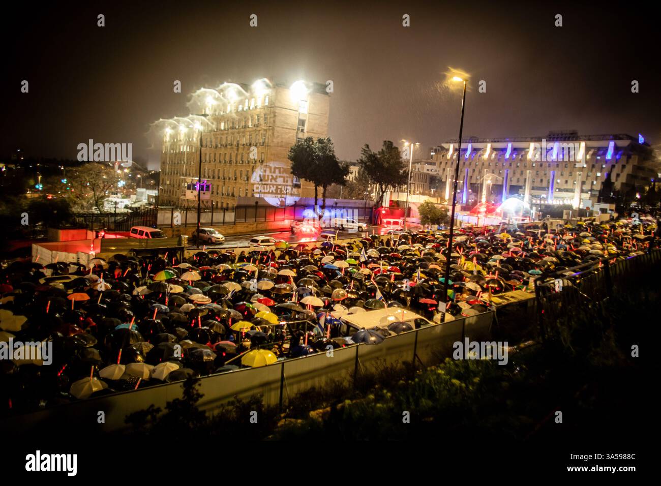 Israeli demonstrators stand in poring rain as they protest outside ...