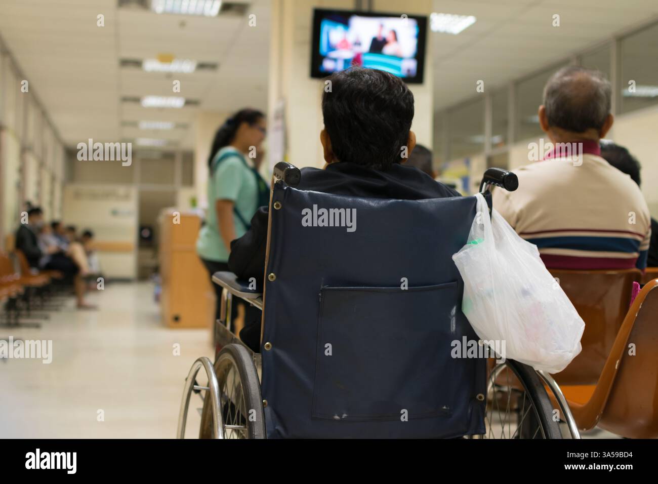 Patient elderly on wheelchair and many patient waiting a doctor and ...