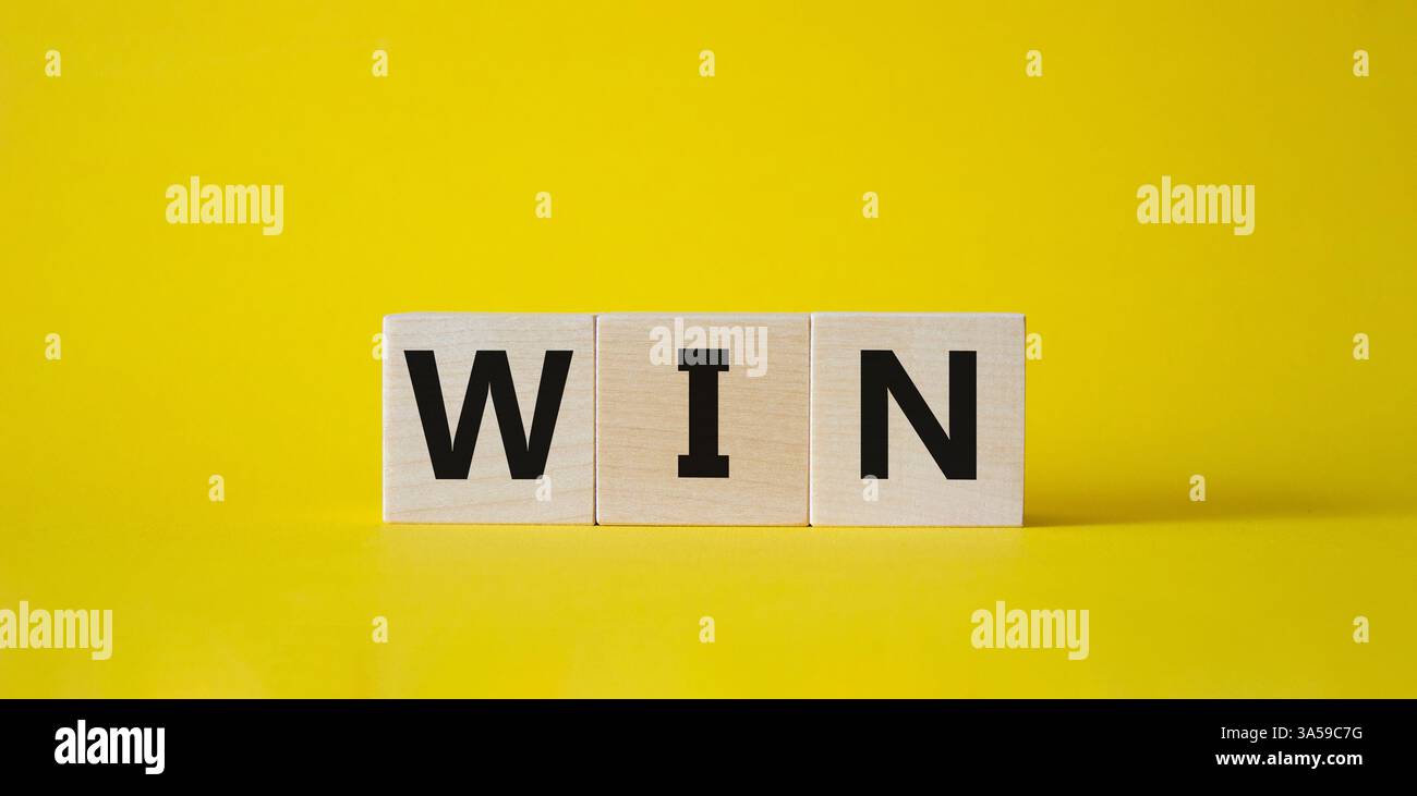 Win symbol. Wooden blocks with words Win. Beautiful yellow background ...