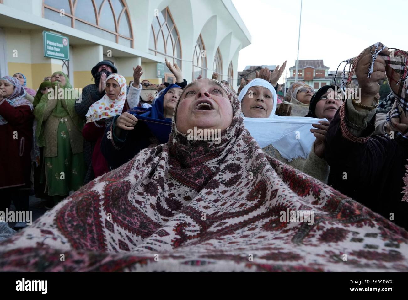 Muslim devotees pray as the head priest displays a holy relic believed ...