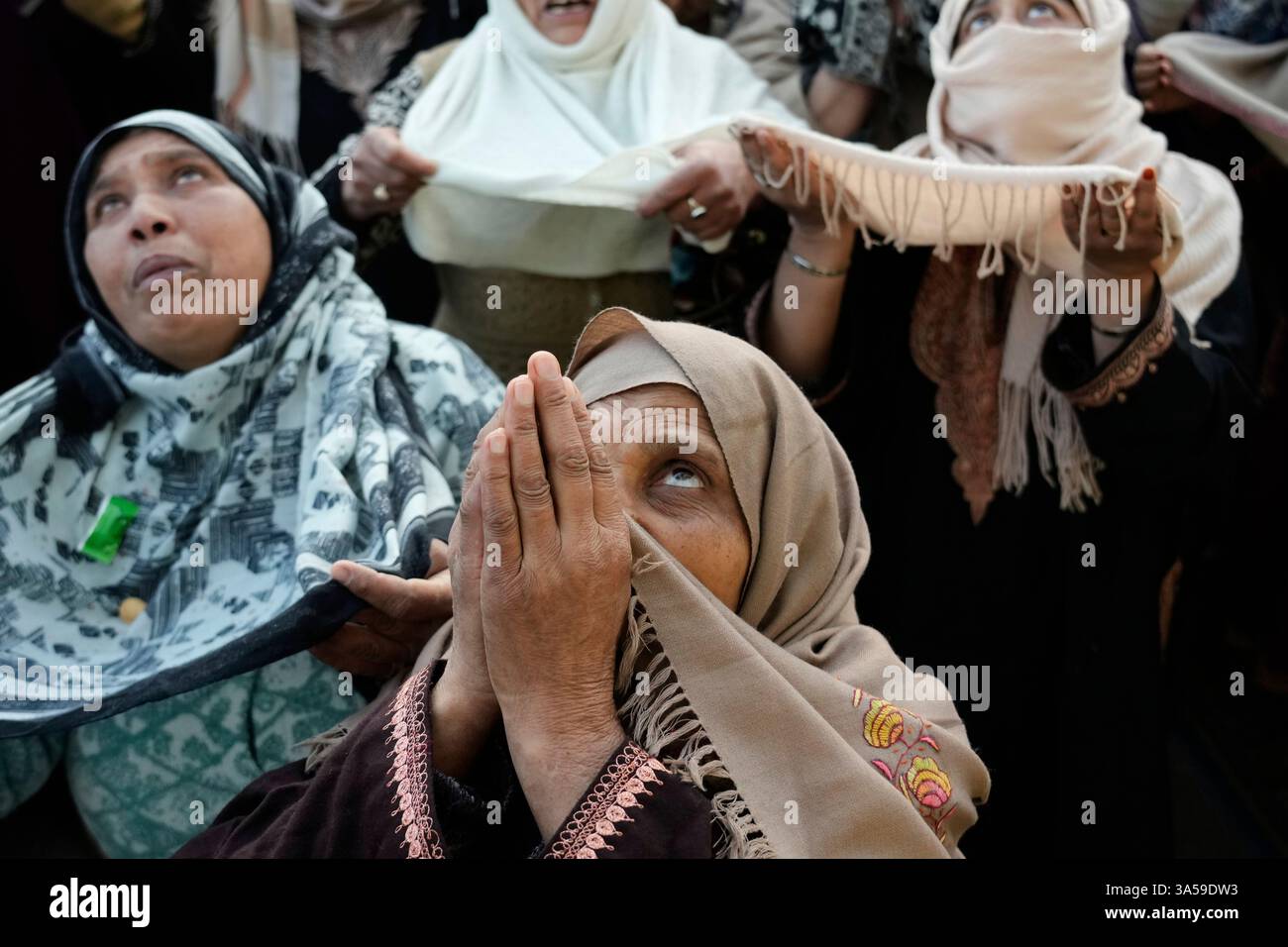 Muslim devotees pray as the head priest displays a holy relic believed ...