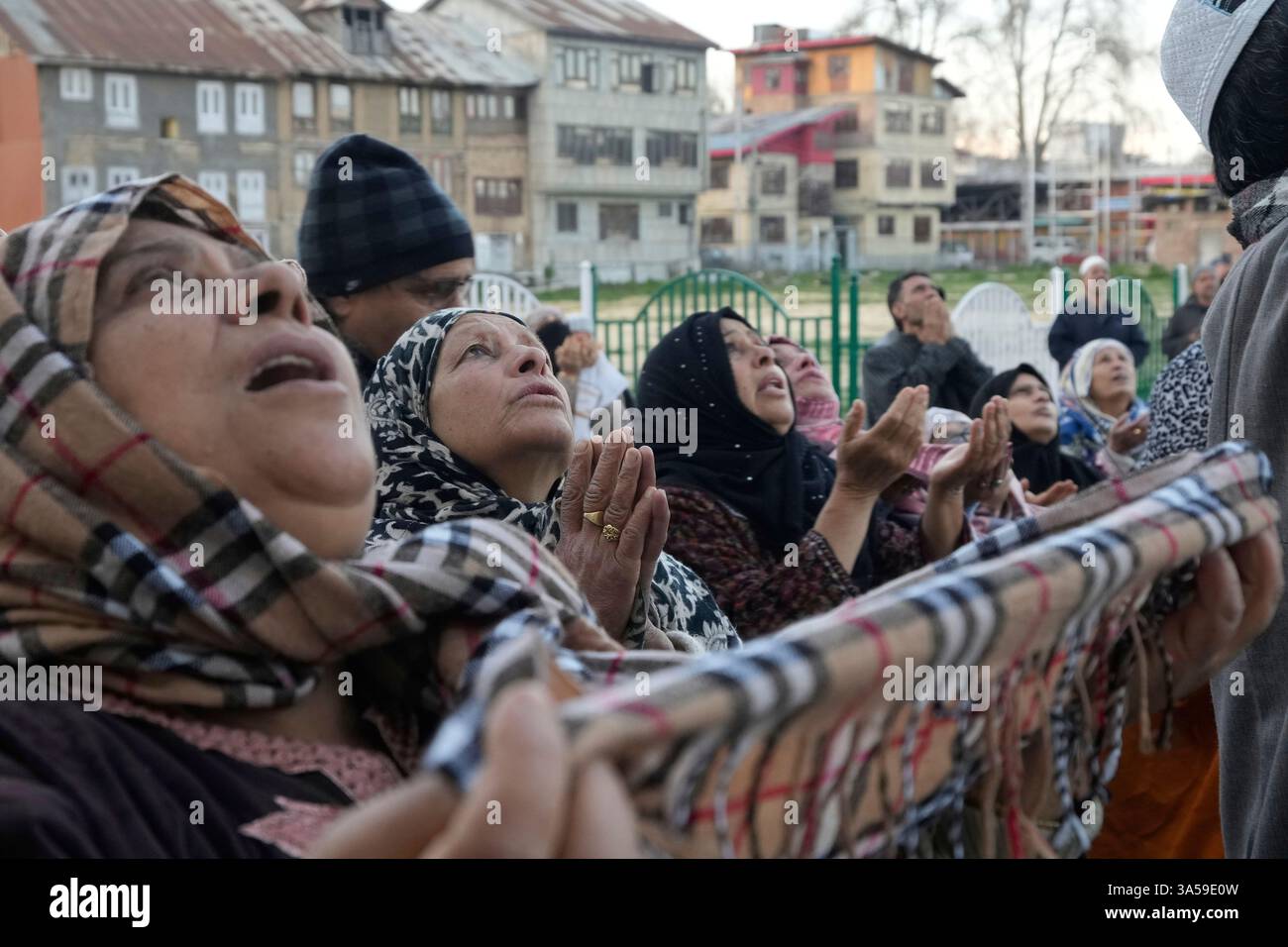 Muslim devotees pray as the head priest displays a holy relic believed ...