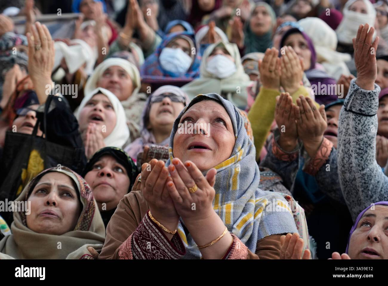 Muslim devotees pray as the head priest displays a holy relic believed ...