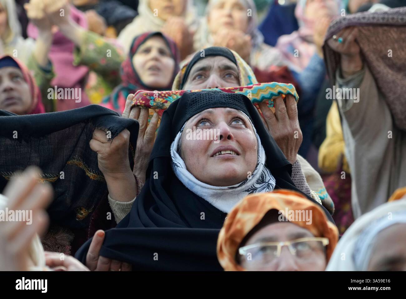Muslim devotees pray as the head priest displays a holy relic believed ...