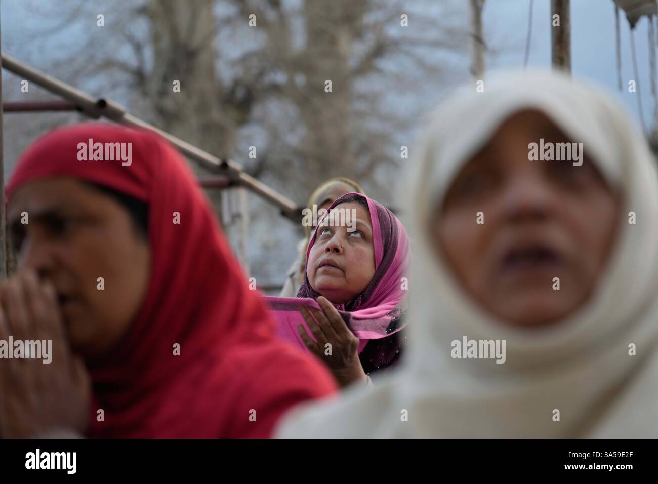 Muslim devotees pray as the head priest displays a holy relic believed ...