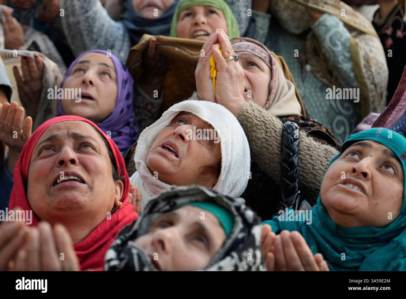 Muslim devotees pray as the head priest displays a holy relic believed ...