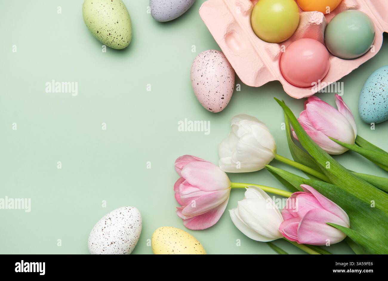 Colorful easter eggs and pink and white tulips creating a spring ...