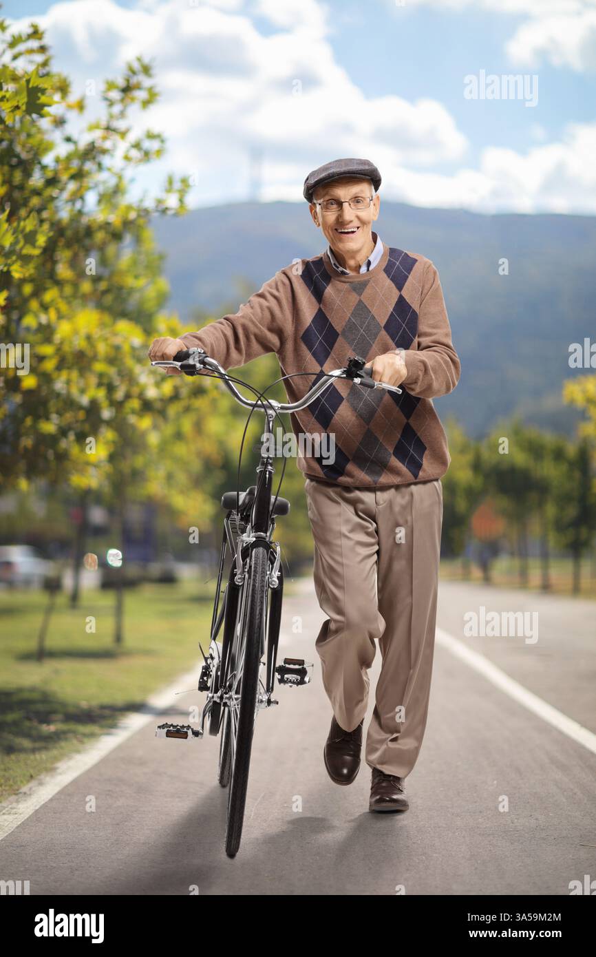 Person walking while pushing a bicycle hi-res stock photography and ...