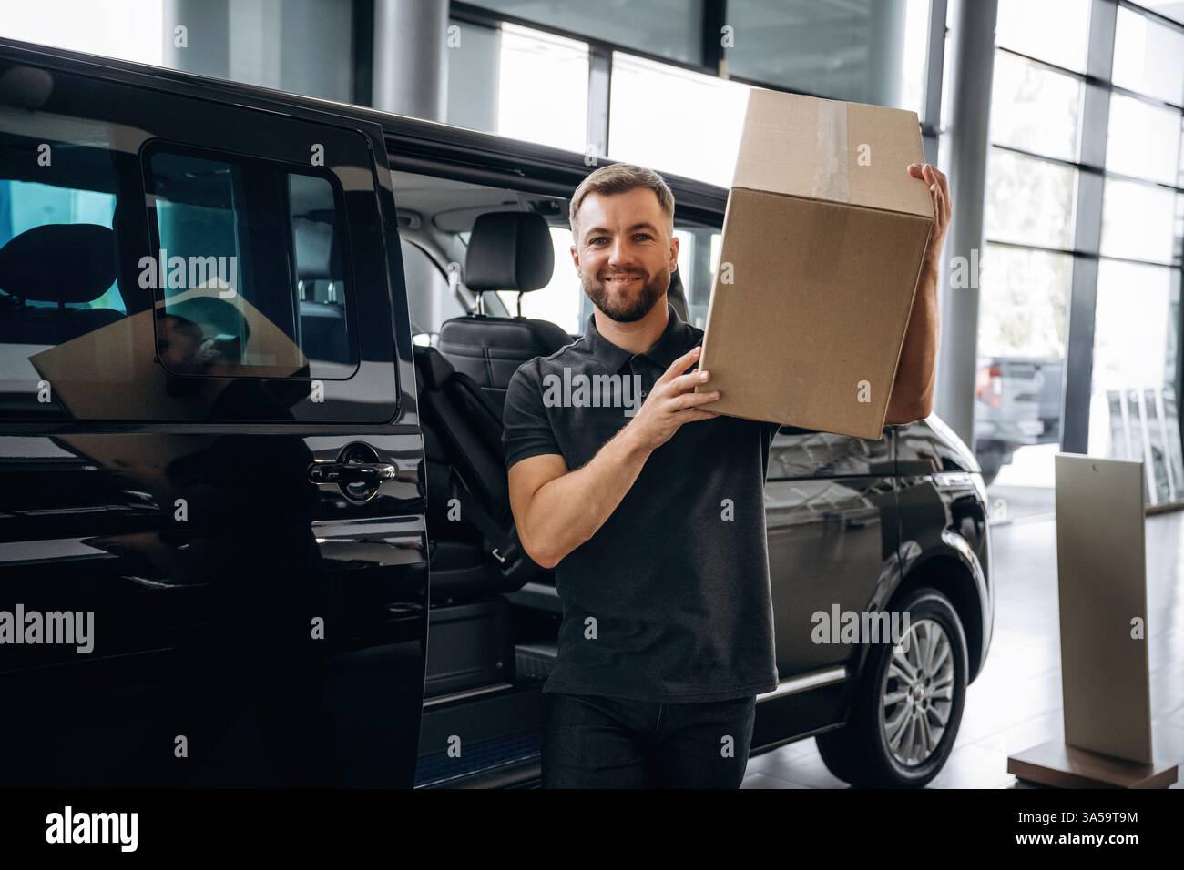 Box is on the shoulder. Delivery man or loader is near the car with ...